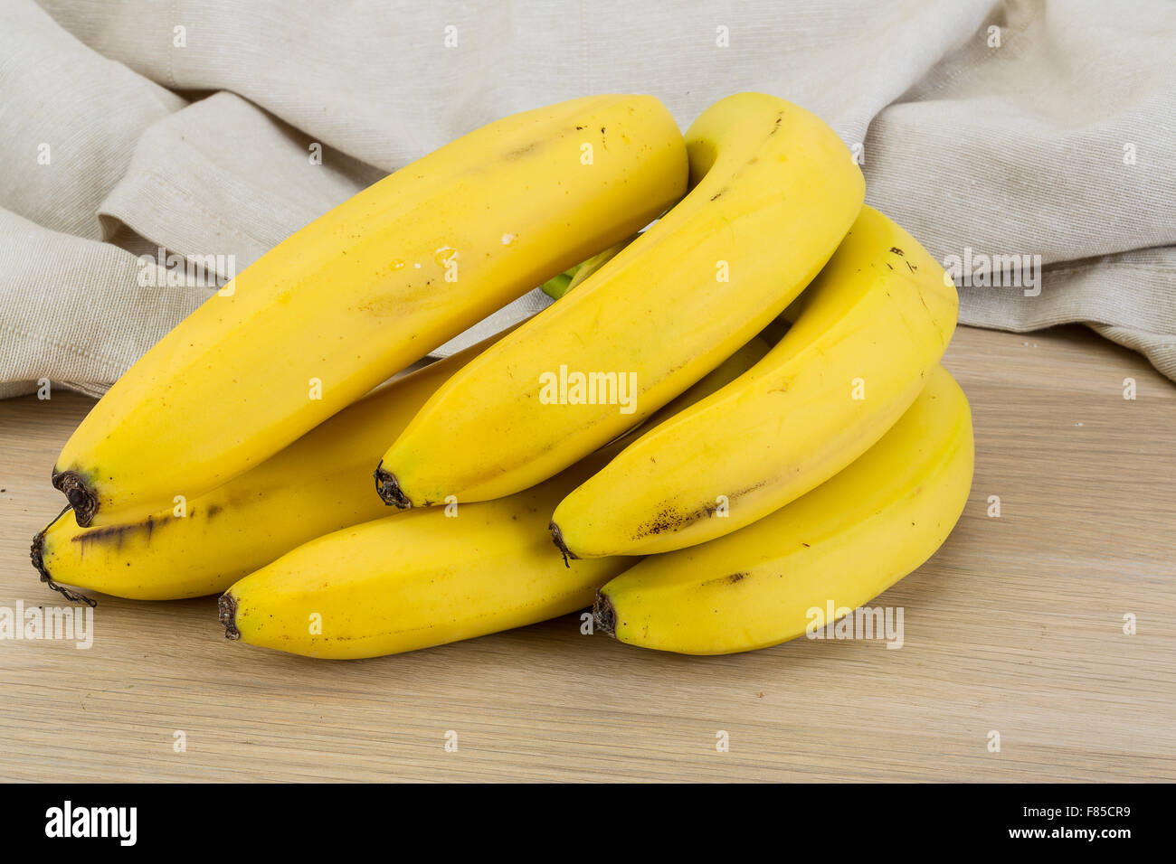 Ripe Banana branch on the wooden background Stock Photo - Alamy