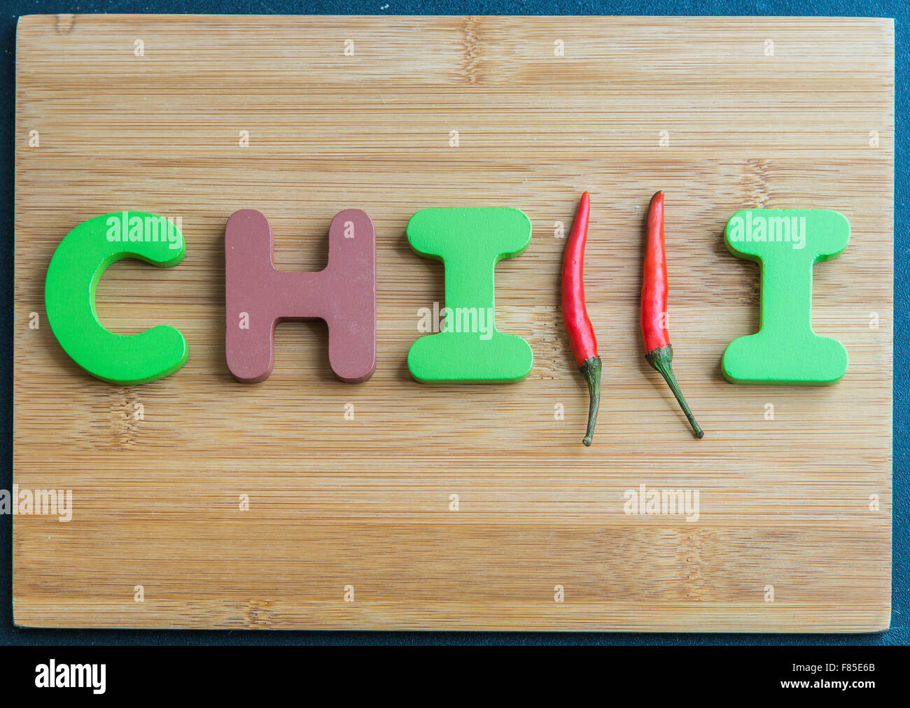 Chilli wooden word on chopping block Stock Photo - Alamy