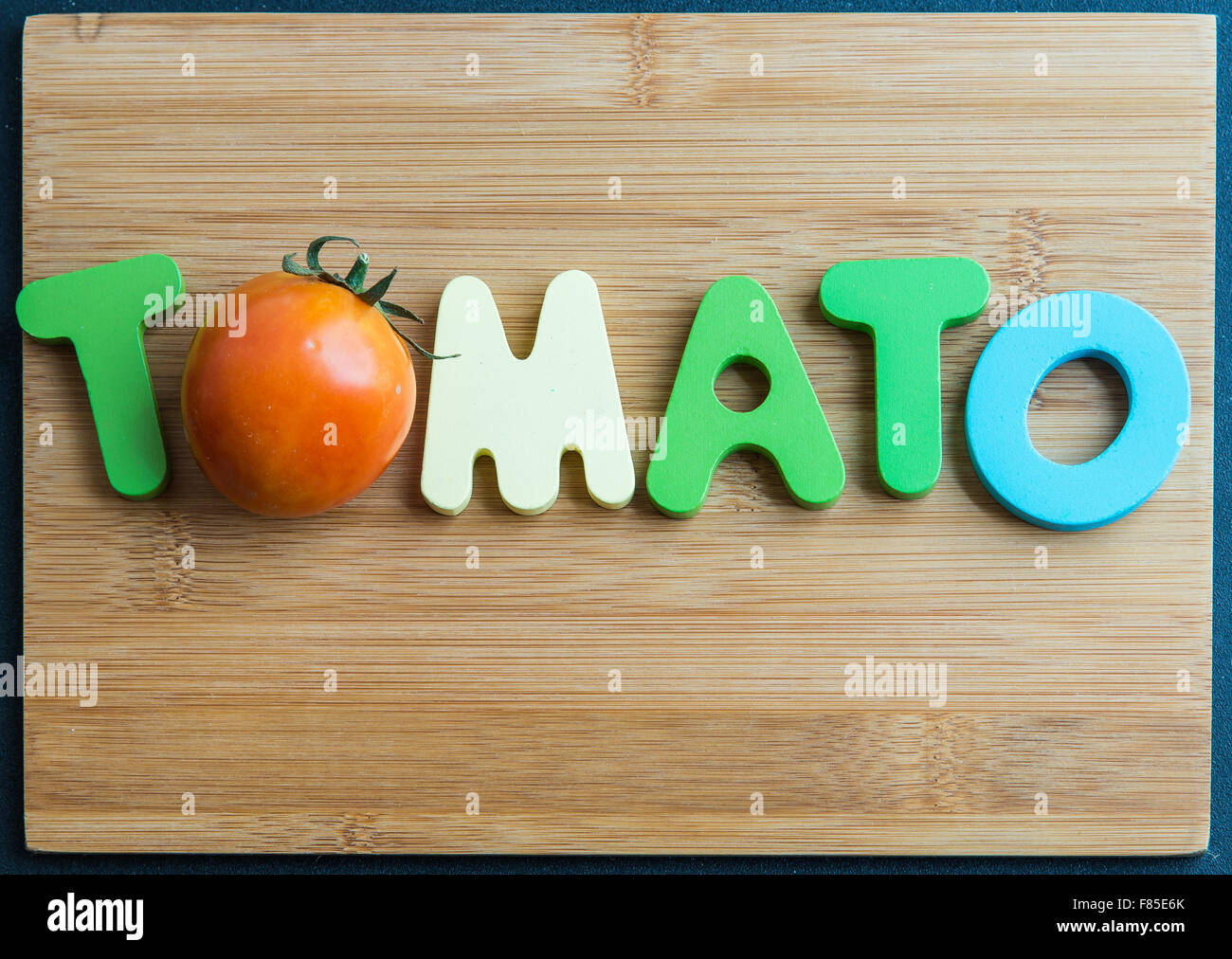 Tomato wooden word on chopping block Stock Photo - Alamy