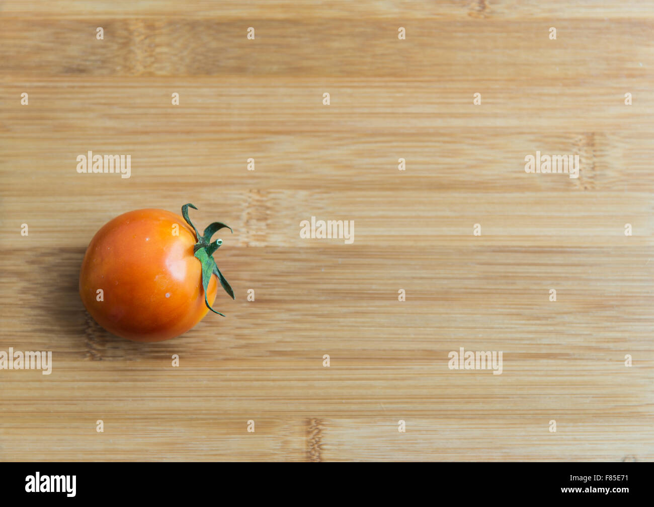 A tomato on wooden Chopping block Stock Photo - Alamy