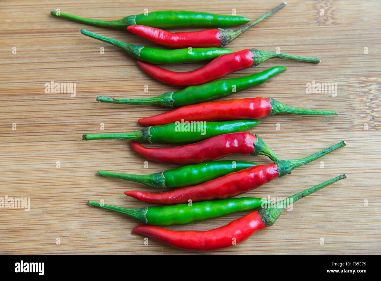 Green chilli pepper and Red chilli pepper on center of chopping block 2 ...