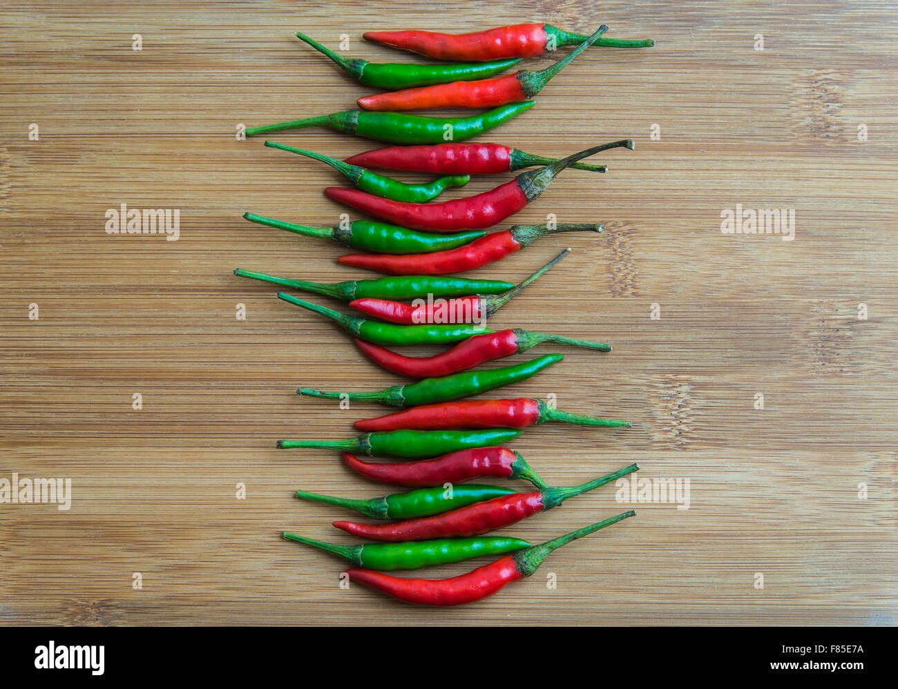 Green chilli pepper and Red chilli pepper on center of chopping block ...