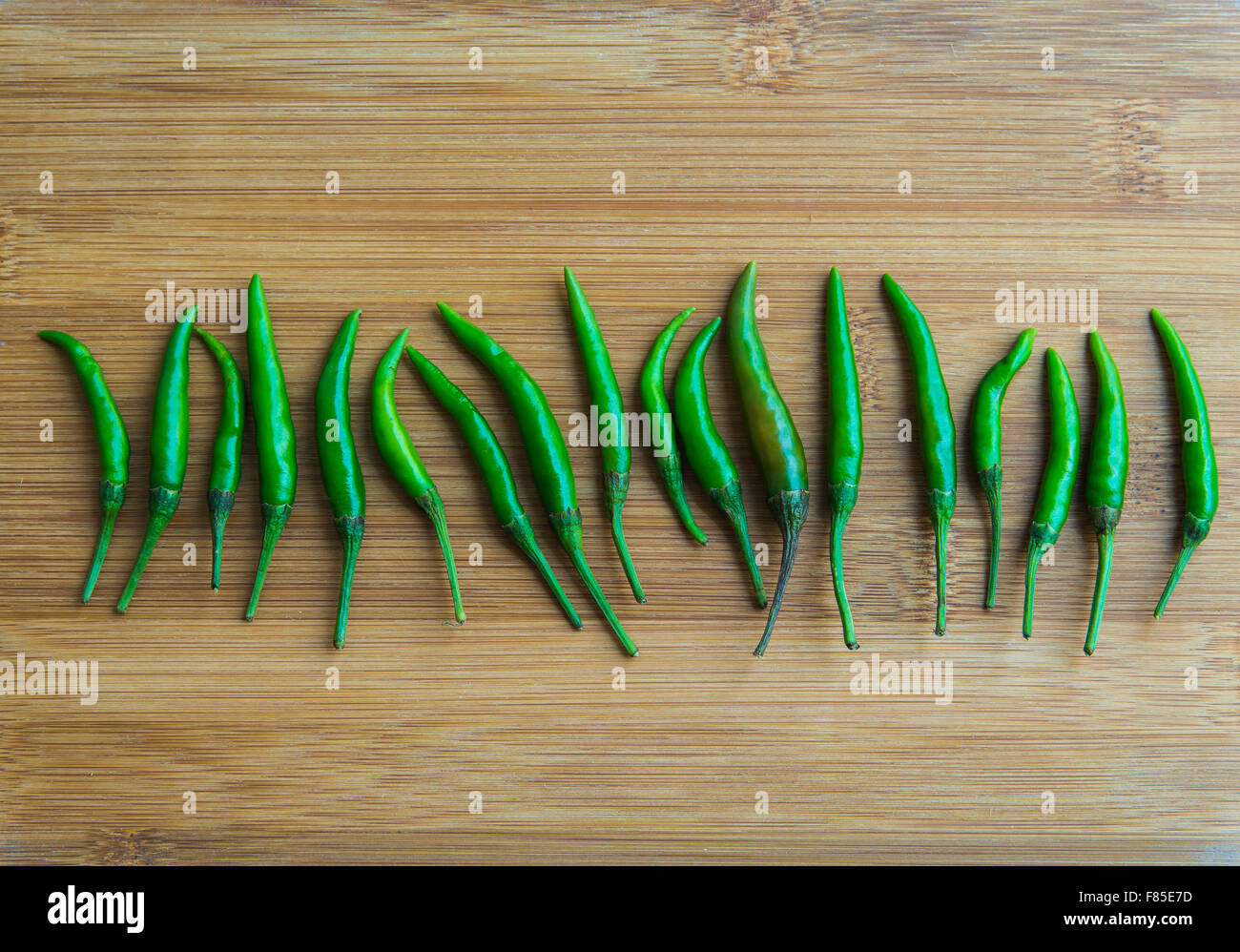 Green chilli pepper on chopping block Stock Photo - Alamy