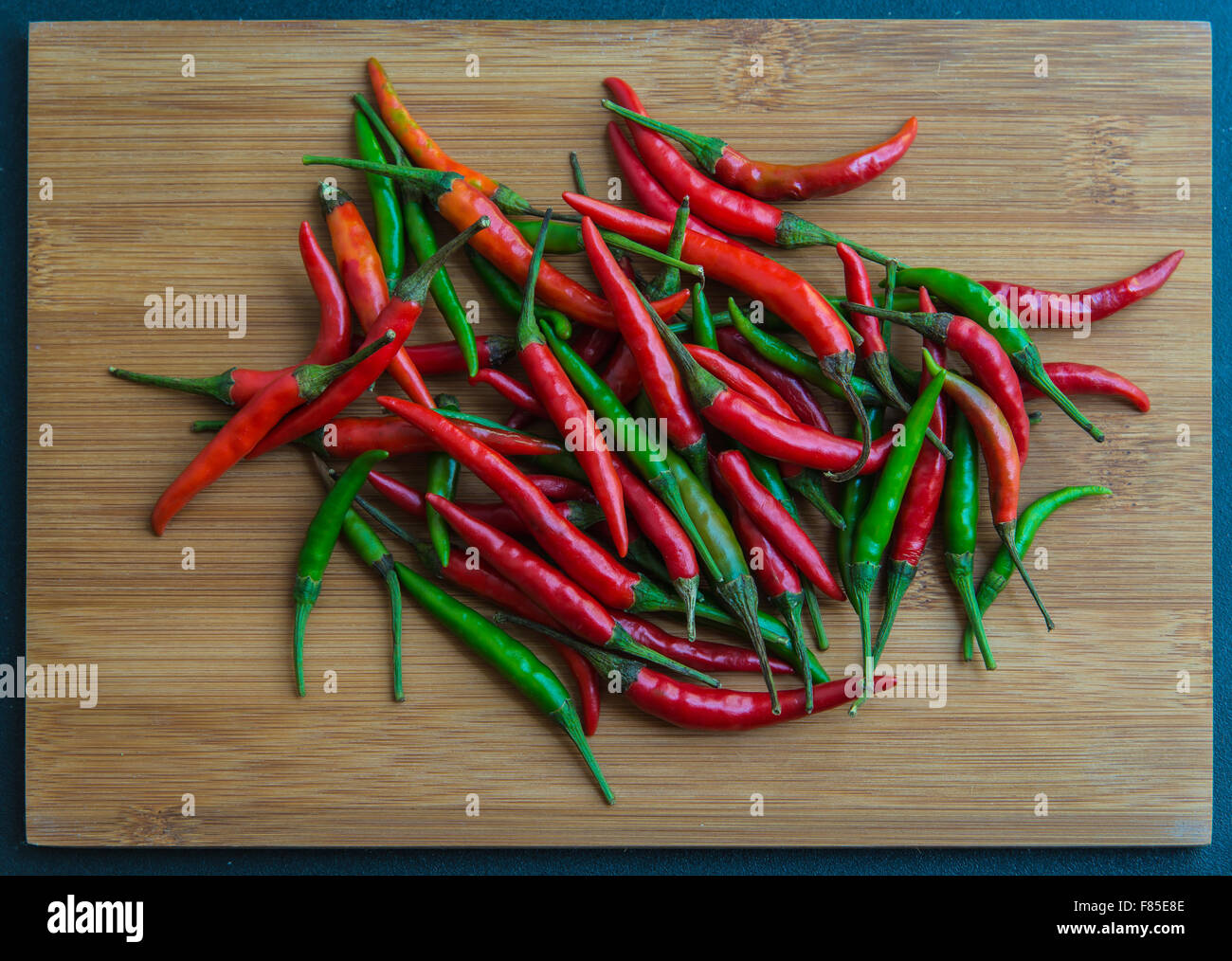 Red and Green chilli pepper on chopping block Stock Photo - Alamy