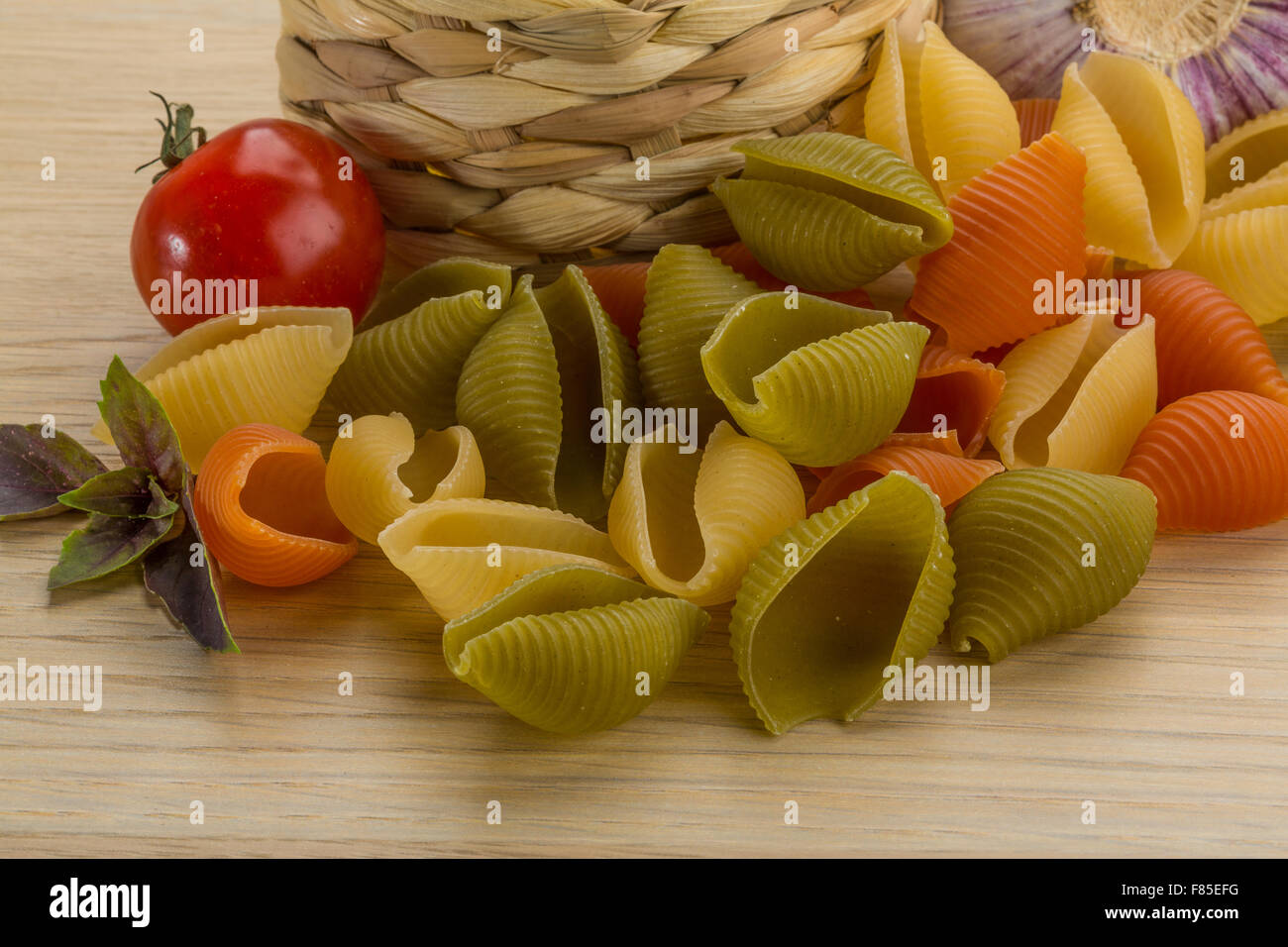 Raw macaroni - shell pasta with herbs Stock Photo - Alamy