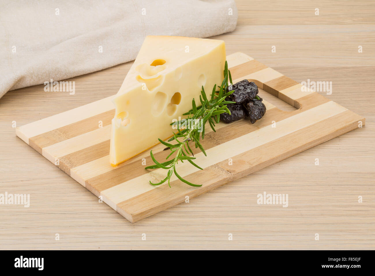 Yellow Cheese maasdam - on the board with herbs Stock Photo - Alamy