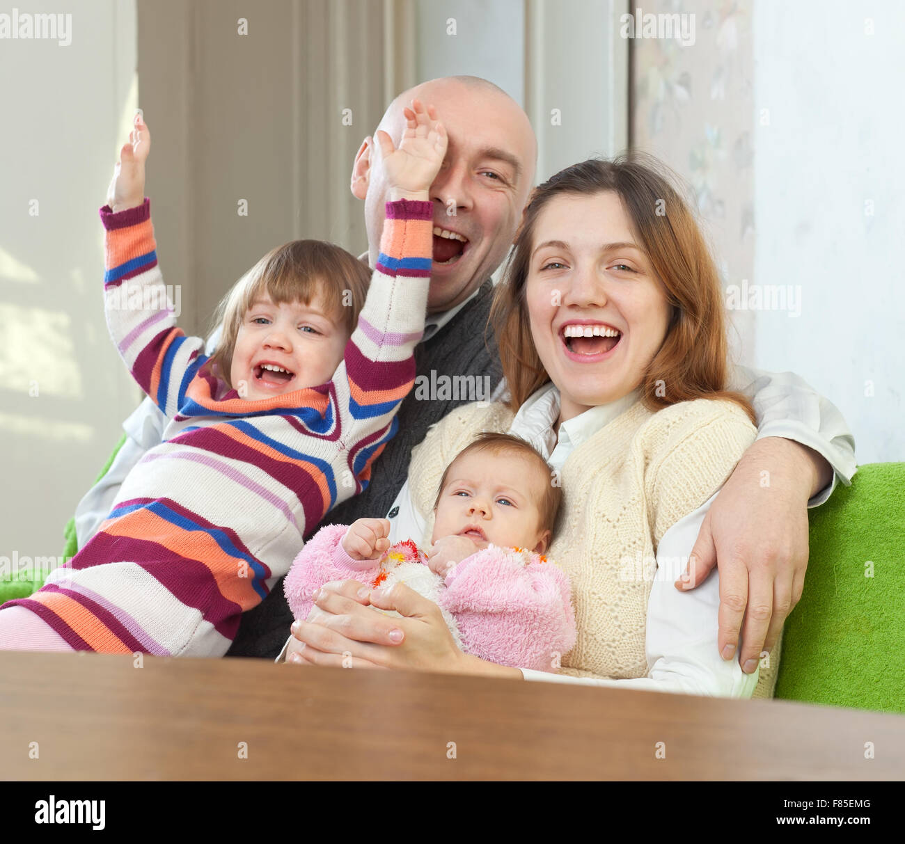 Happy family of four with in home Stock Photo - Alamy