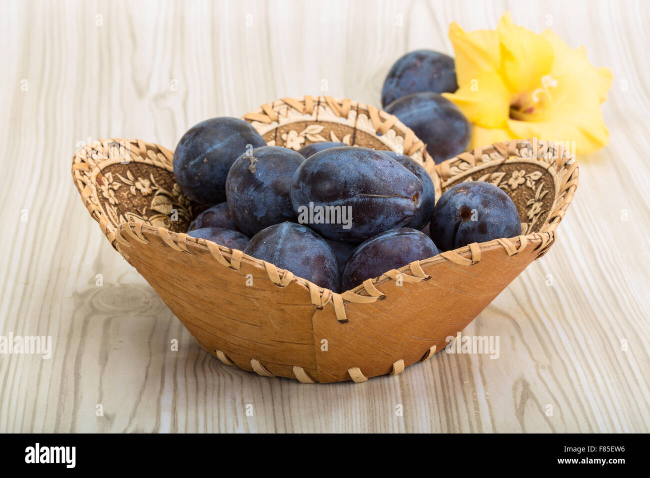 Fresh ripe prunes in the bowl on wooden background Stock Photo - Alamy