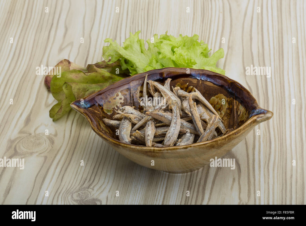 Dries anchovy - small fishes in the bowl Stock Photo - Alamy