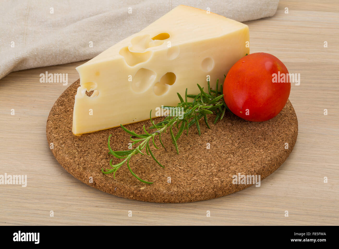 Yellow Cheese maasdam - on the board with herbs Stock Photo - Alamy