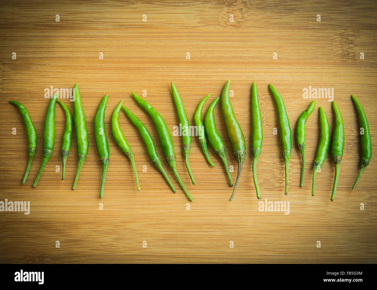 Green chilli pepper on chopping block 2 Stock Photo - Alamy