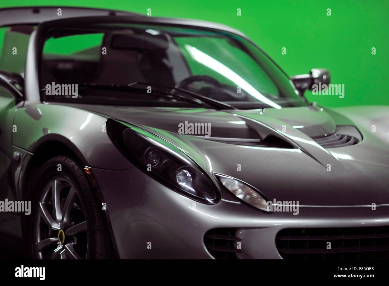 detail of sport silver car with green background Stock Photo - Alamy