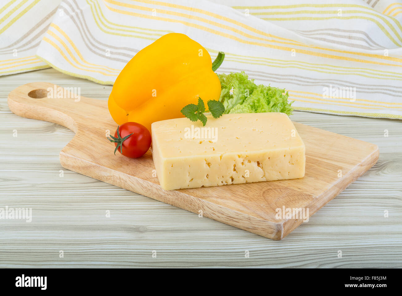 Block of Yellow cheese with herbs on wood Stock Photo - Alamy