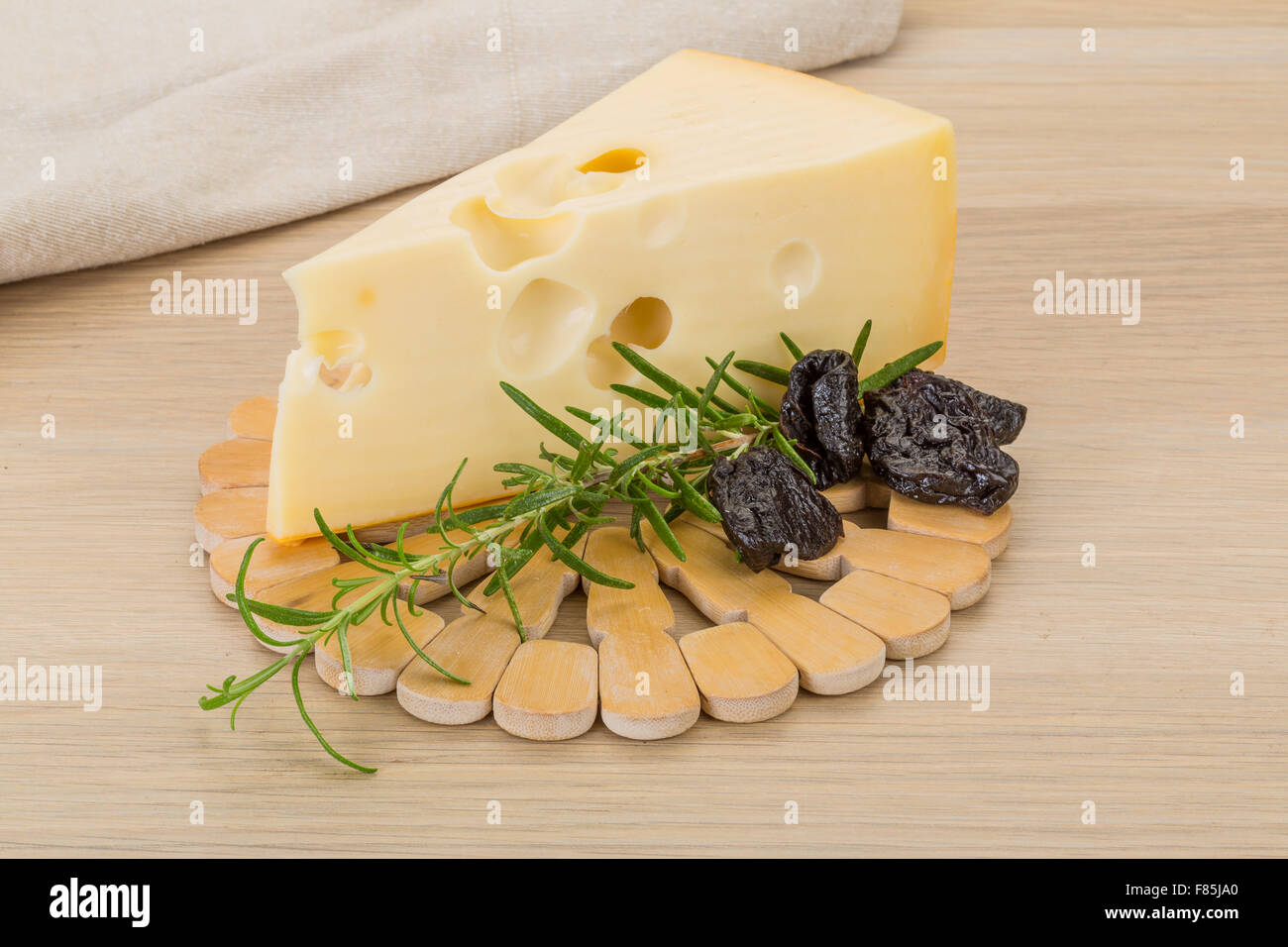 Yellow Cheese maasdam - on the board with herbs Stock Photo - Alamy