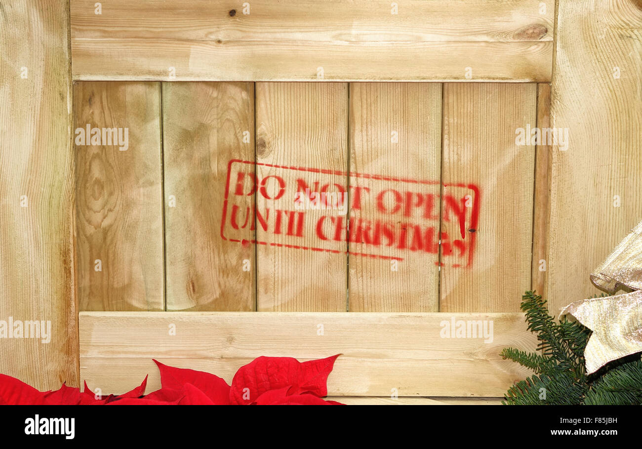 Close up of wooden box with red text stating do not open until ...