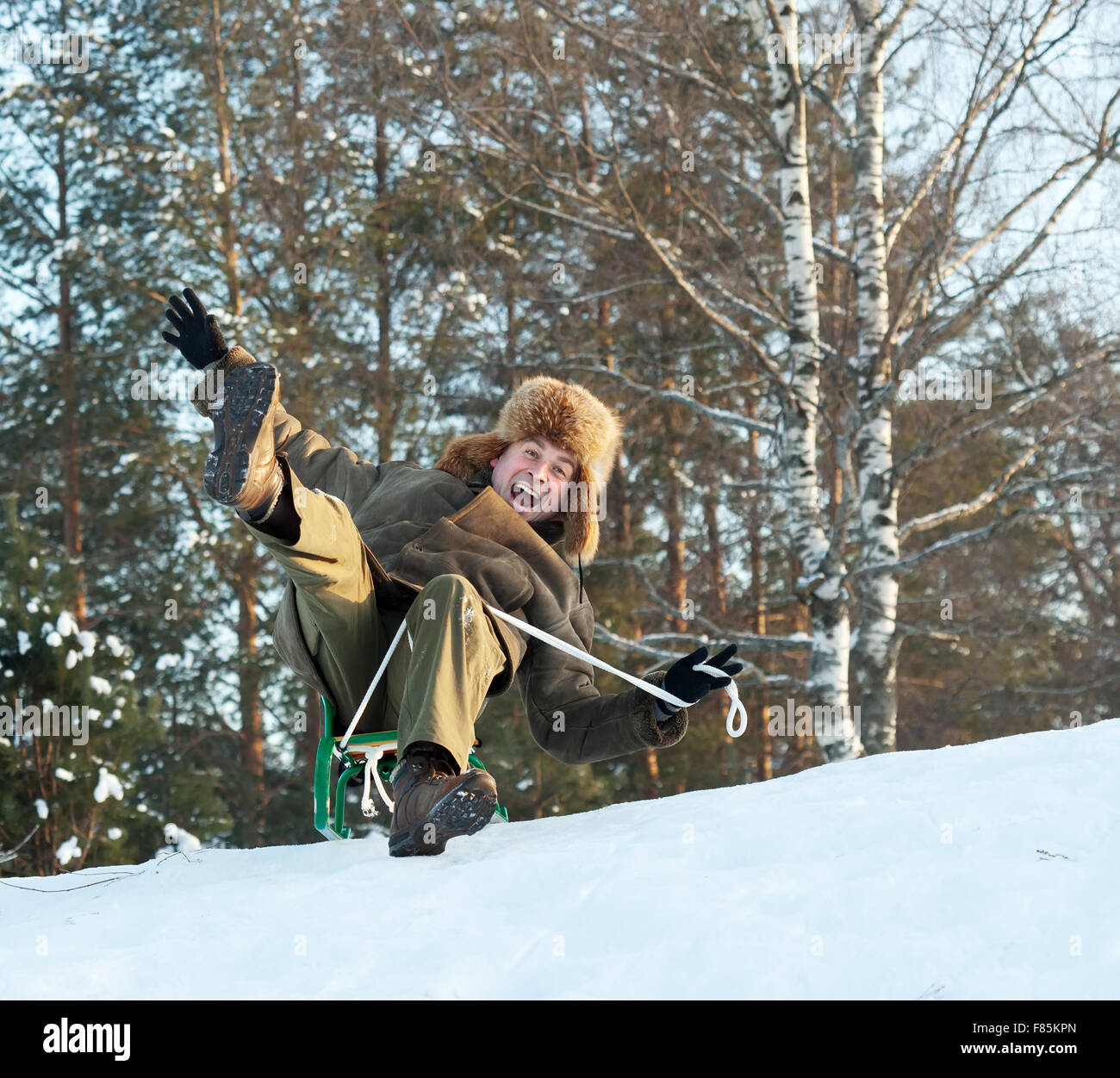 Man sliding on sleds downhill in winter Stock Photo - Alamy
