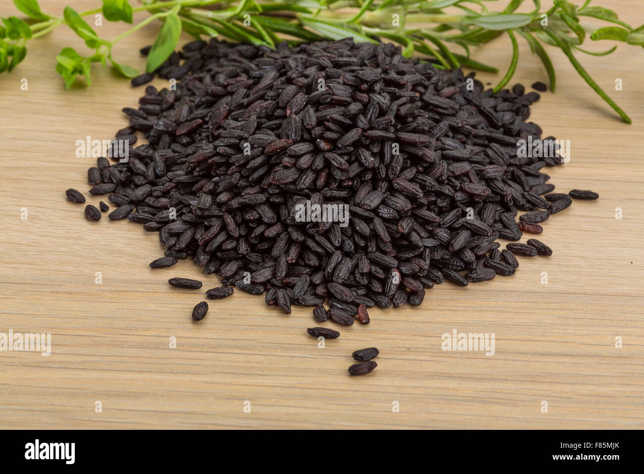 Raw black rice with herbs Stock Photo - Alamy