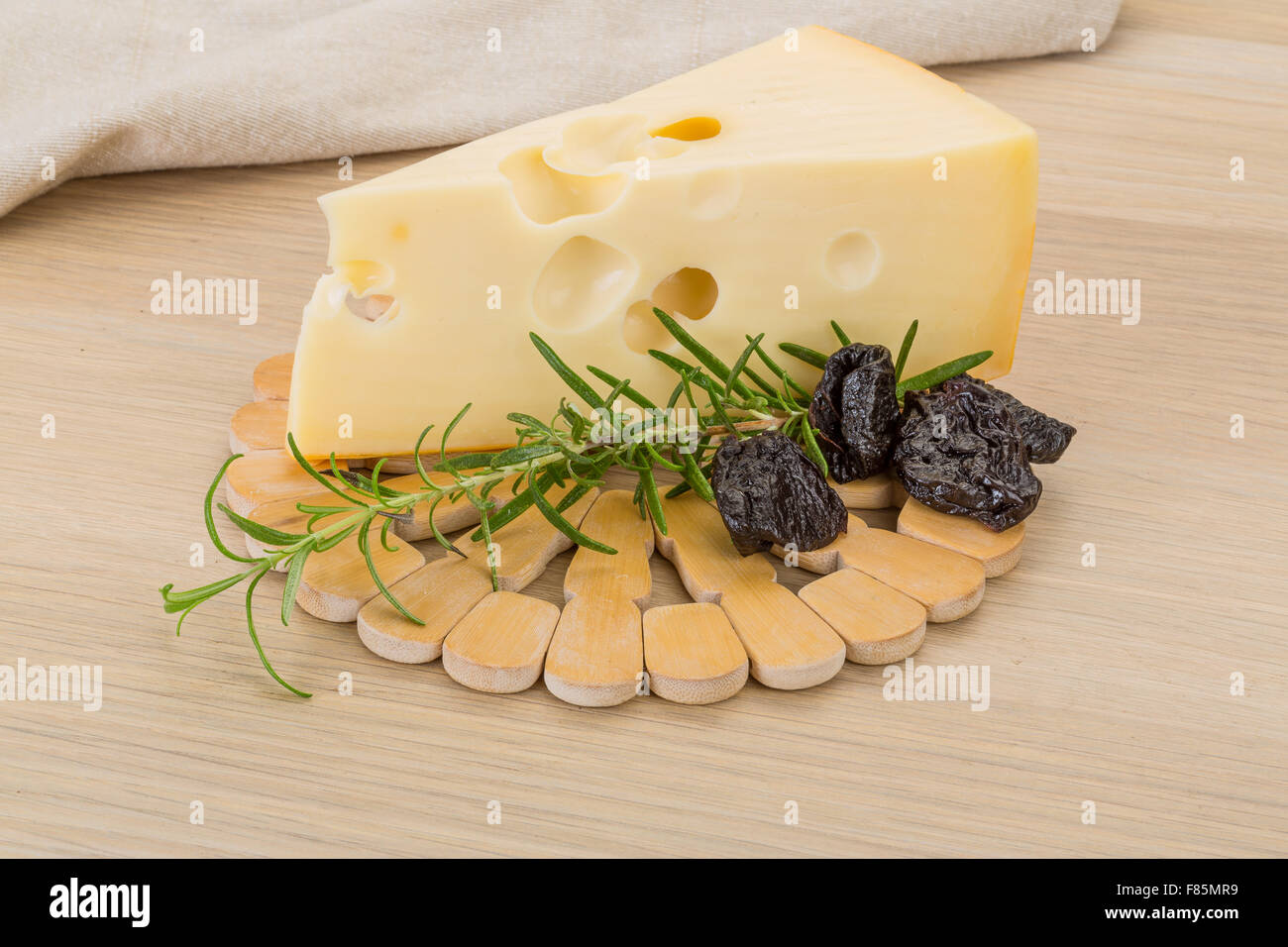 Yellow Cheese maasdam - on the board with herbs Stock Photo - Alamy