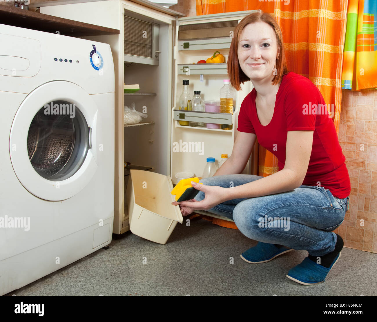 Young woman defrosting the refrigerator at her kitchen Stock Photo - Alamy