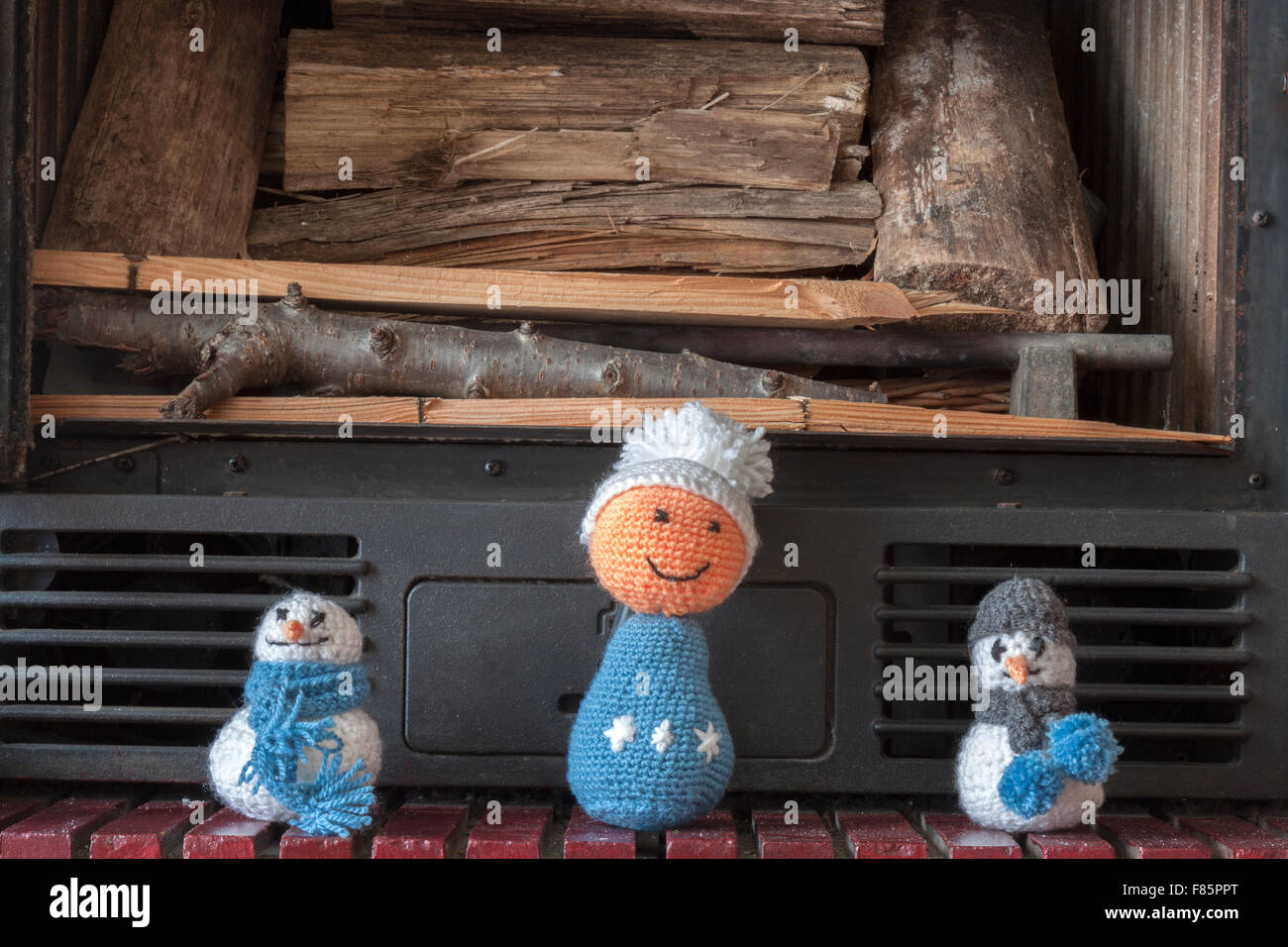a horizontal frontal view of a decorated fireplace with crochet snowmen ...
