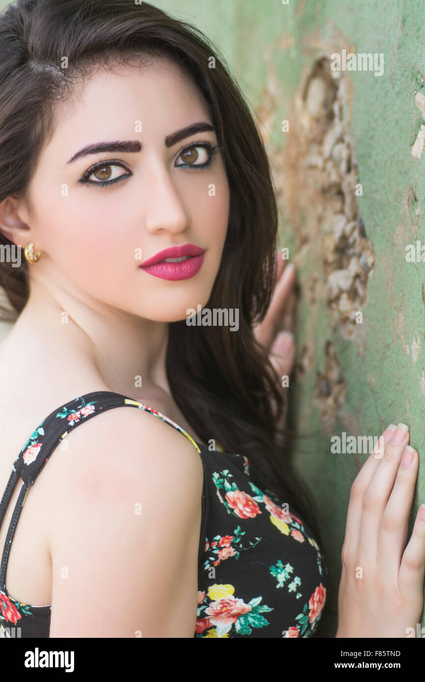 Beautiful young woman leaning against the wall outdoors Stock Photo - Alamy