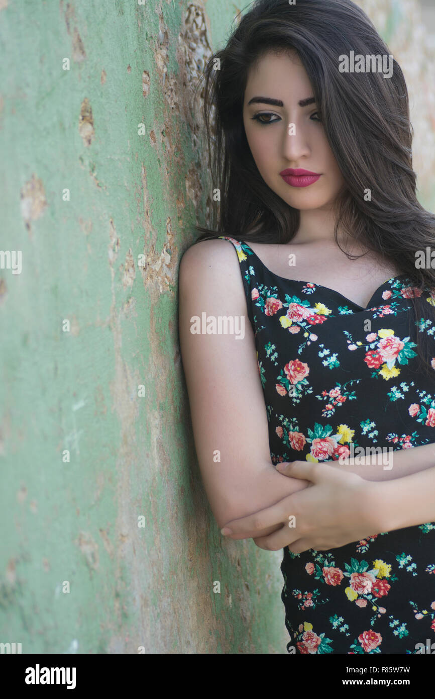 Beautiful young woman leaning against the wall outdoors Stock Photo - Alamy