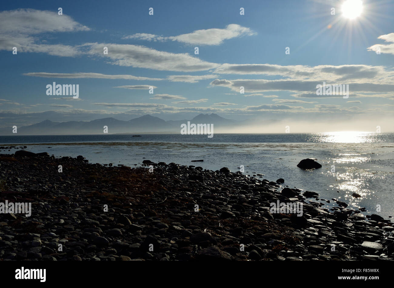 sun over blue ocean and blue sky with heavy moving ocean mist in autumn ...
