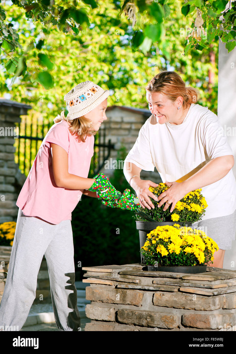 Mom and daughter planting flowers in pots Stock Photo - Alamy