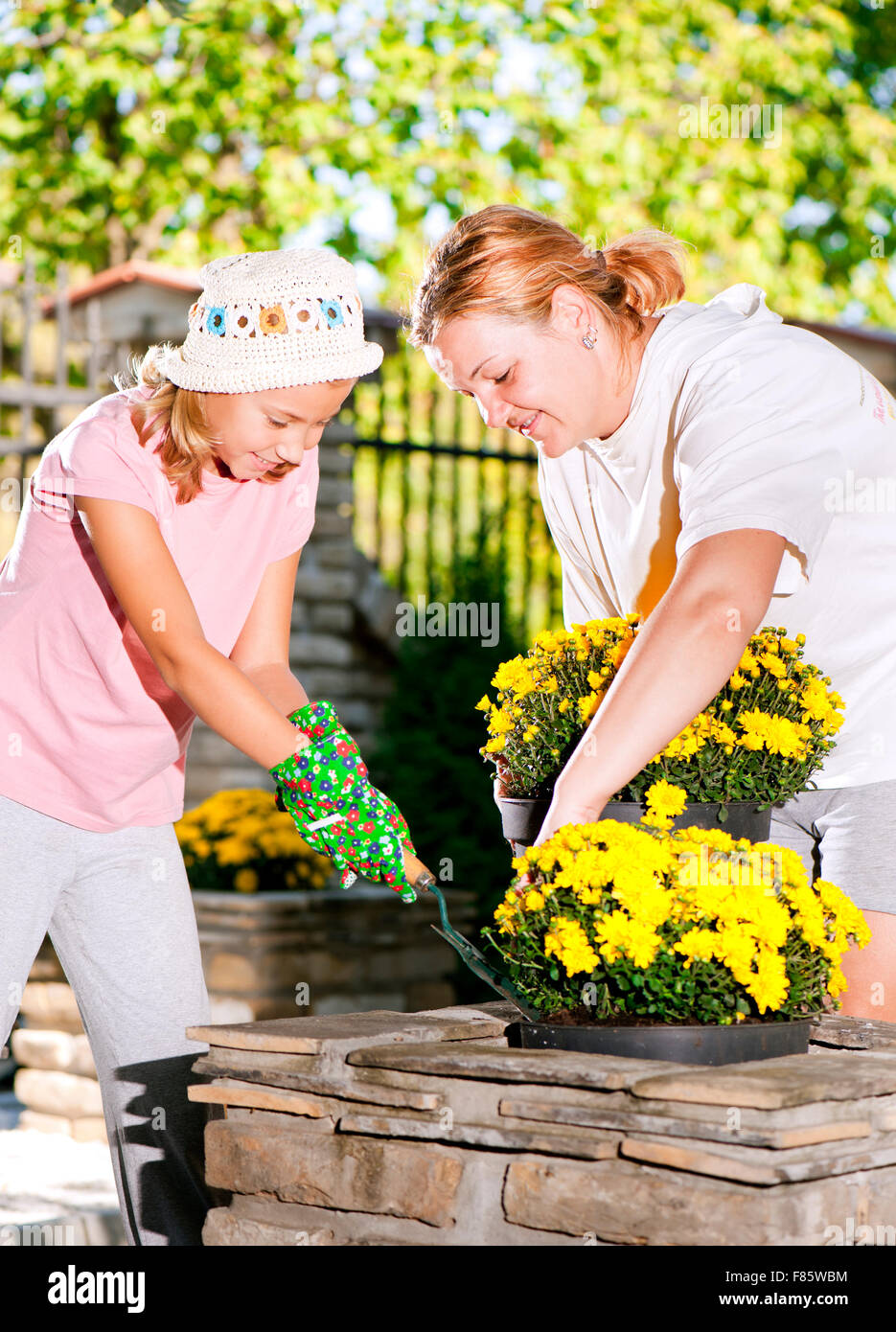 Mom and daughter planting flowers in pots Stock Photo - Alamy