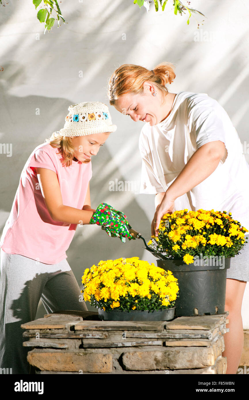 Mom and daughter planting flowers in pots Stock Photo - Alamy