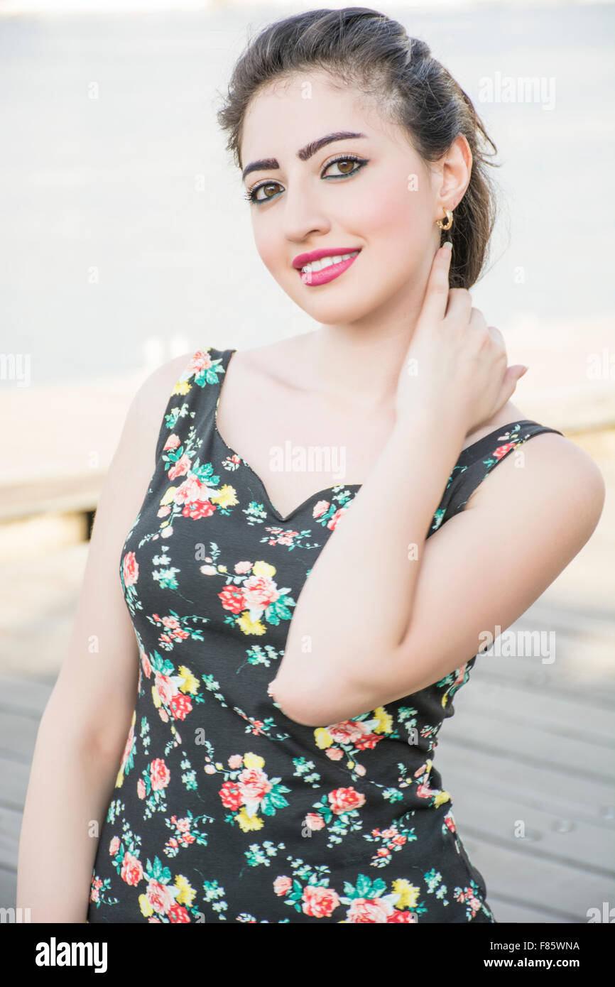 Happy young woman hand touching neck smiling outdoors Stock Photo - Alamy