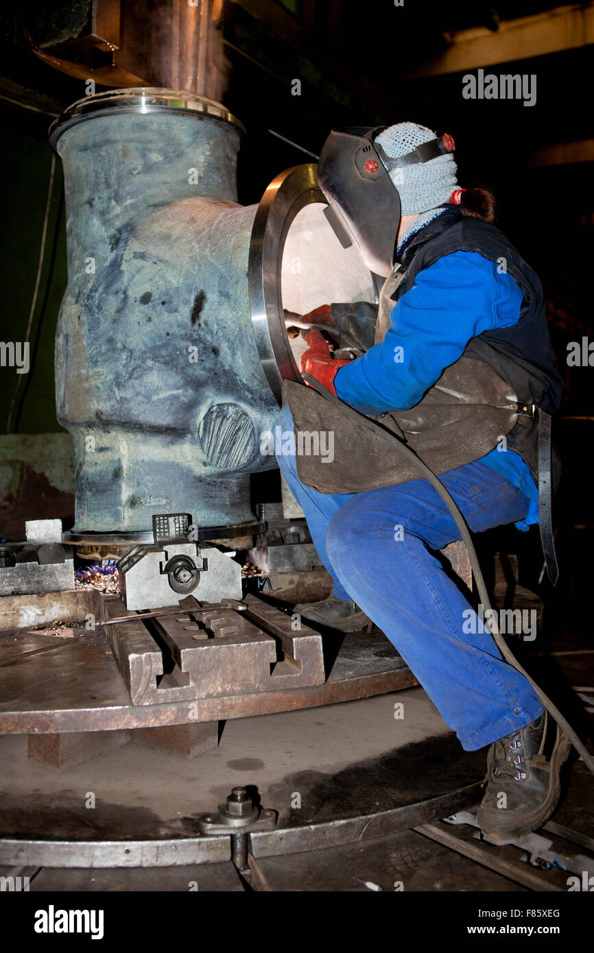 Welder worker is welding a big valve body Stock Photo - Alamy