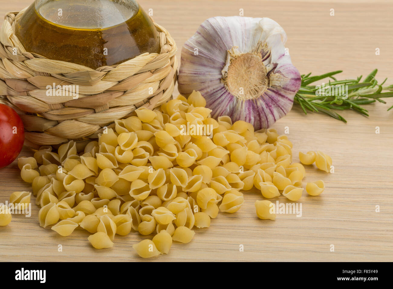 Raw macaroni - shell pasta with herbs Stock Photo - Alamy