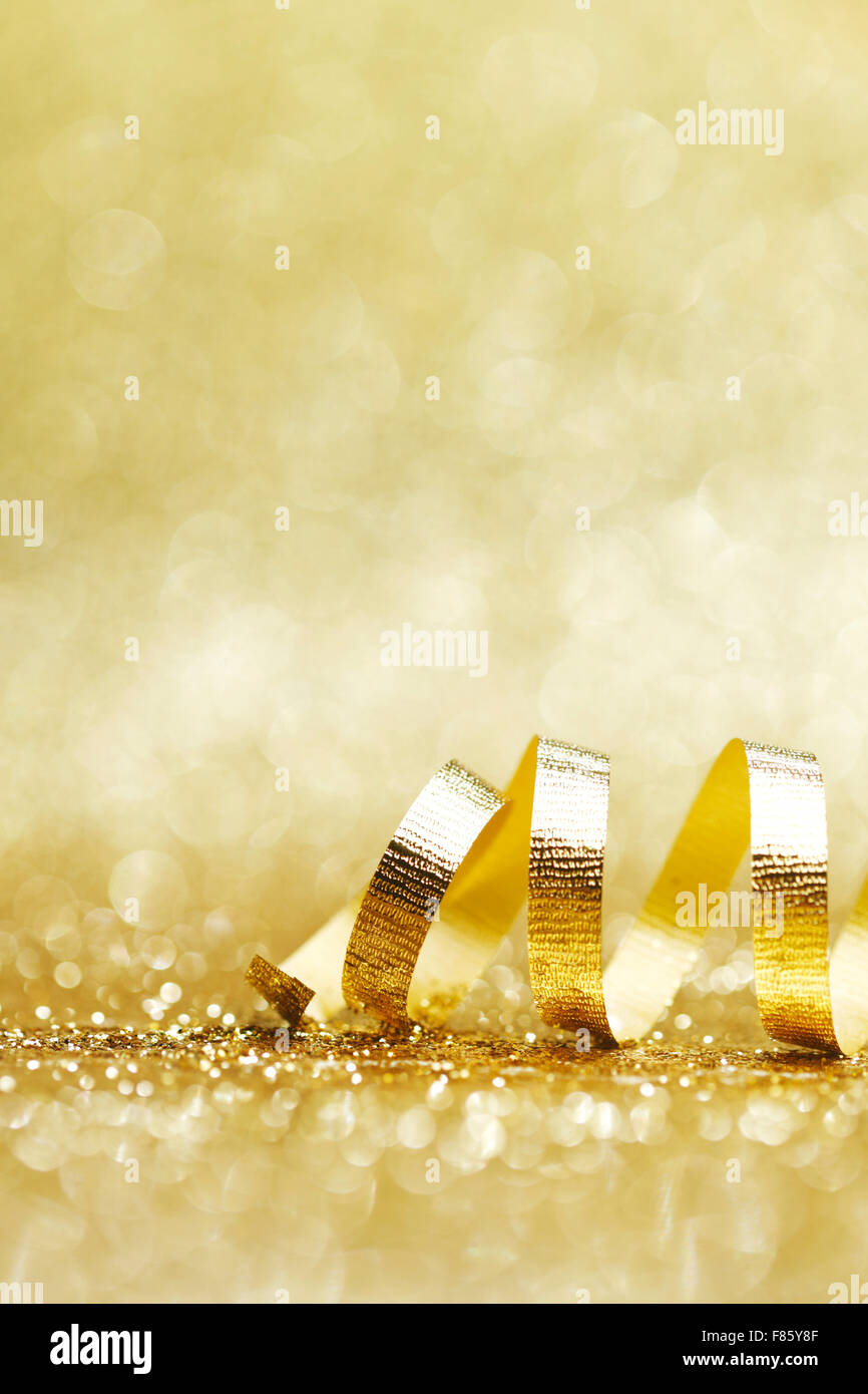 Golden curly ribbon decoration on glitter background close-up Stock ...