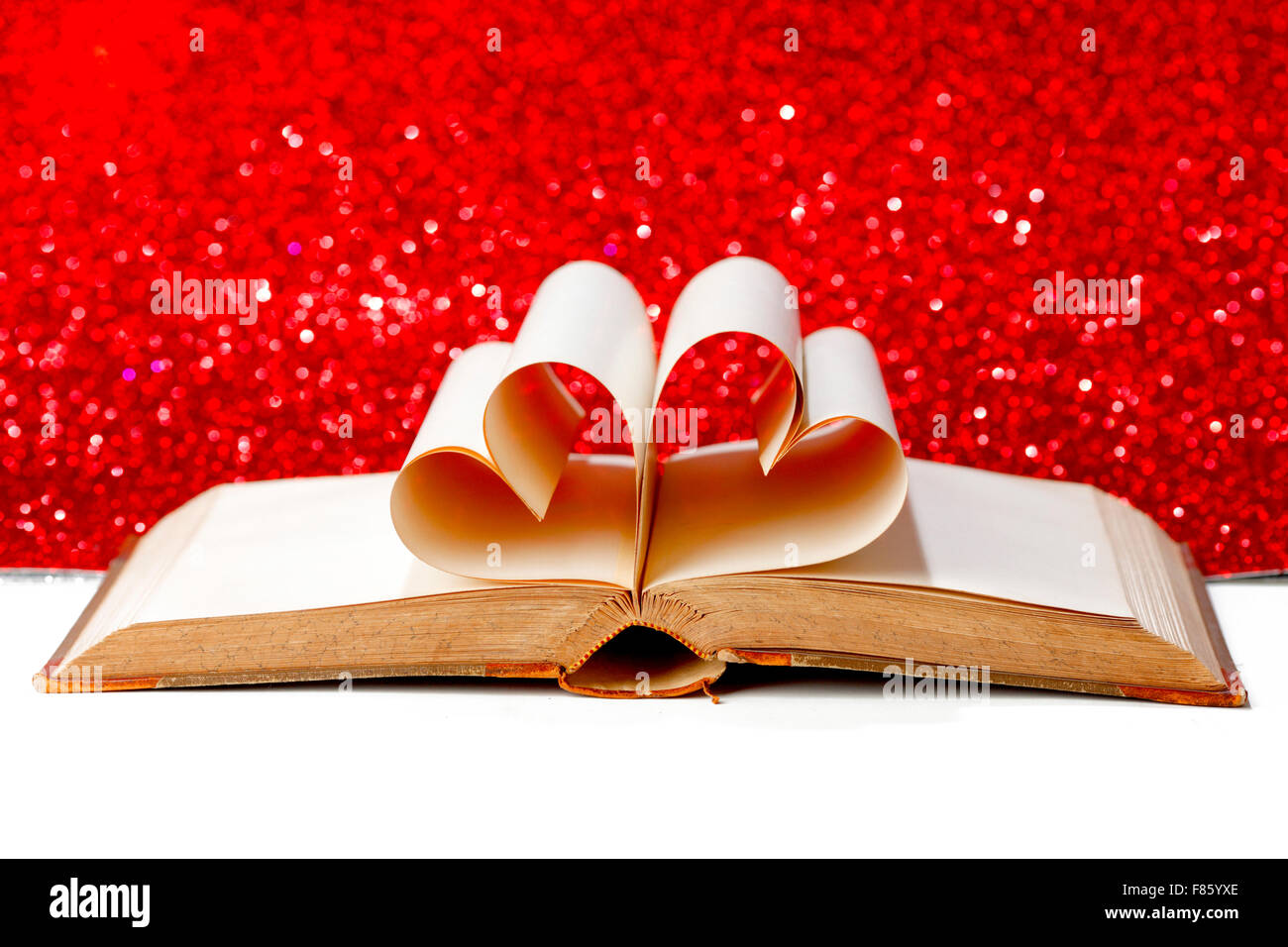 Heart shaped book pages on glitter background Stock Photo - Alamy