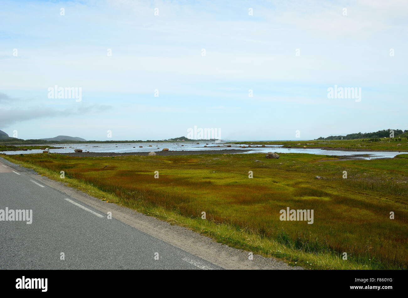 long strait road with ocean water on sides and mighty mountains in ...