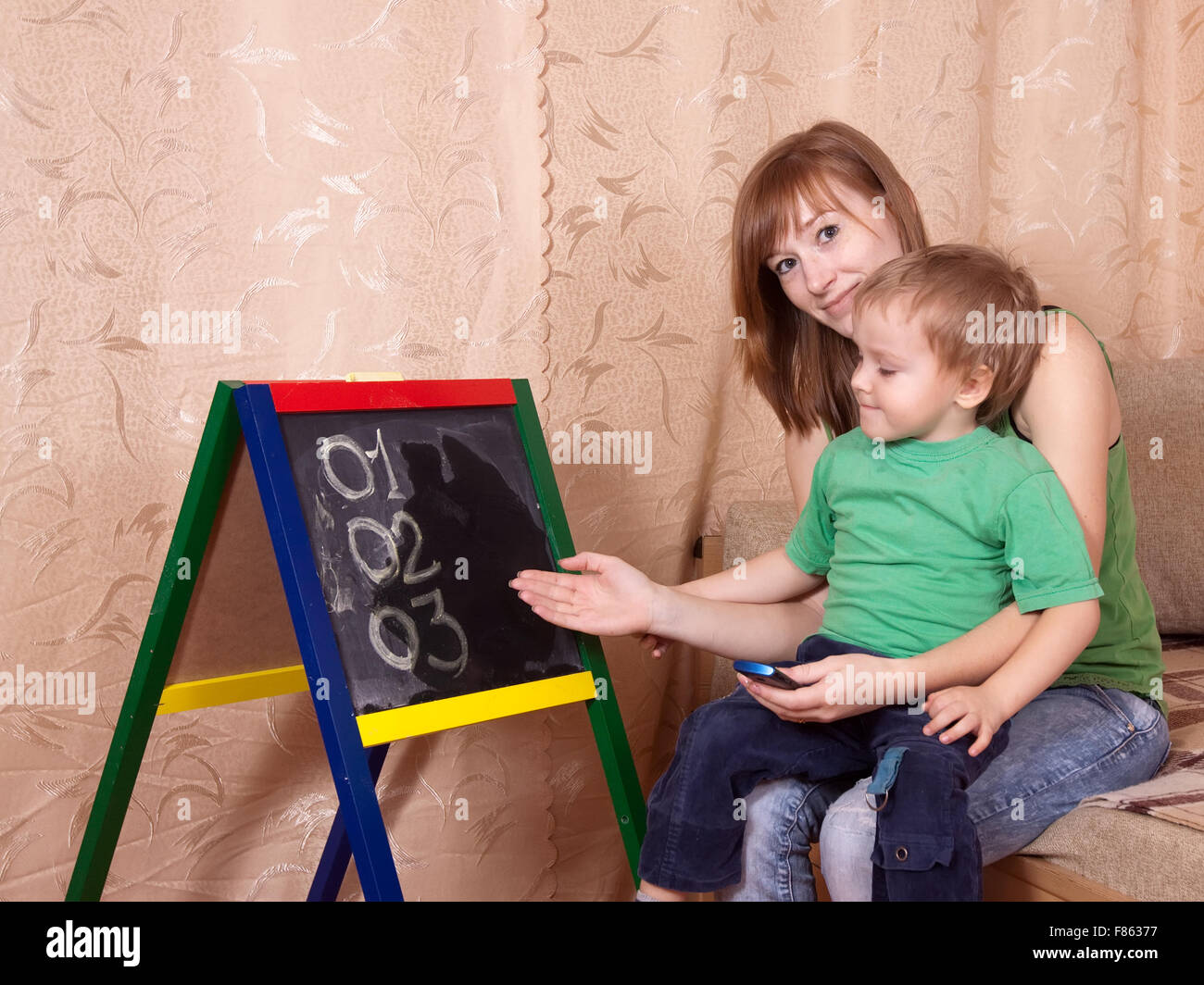 Mother teaches child to emergency phone numbers Stock Photo - Alamy