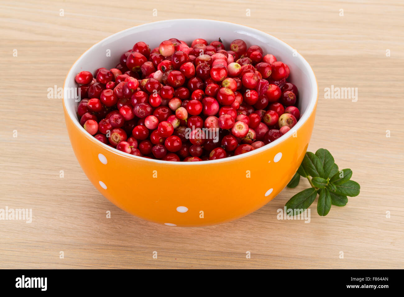 Cowberry in the bowl with leaves Stock Photo - Alamy