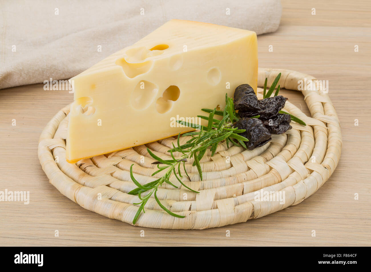 Yellow Cheese maasdam - on the board with herbs Stock Photo - Alamy