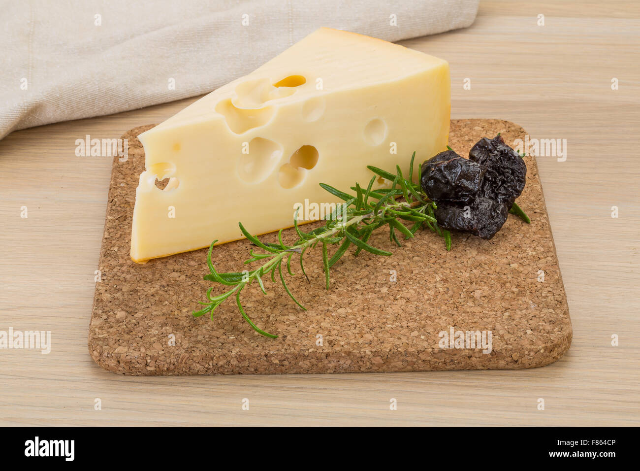 Yellow Cheese maasdam - on the board with herbs Stock Photo - Alamy