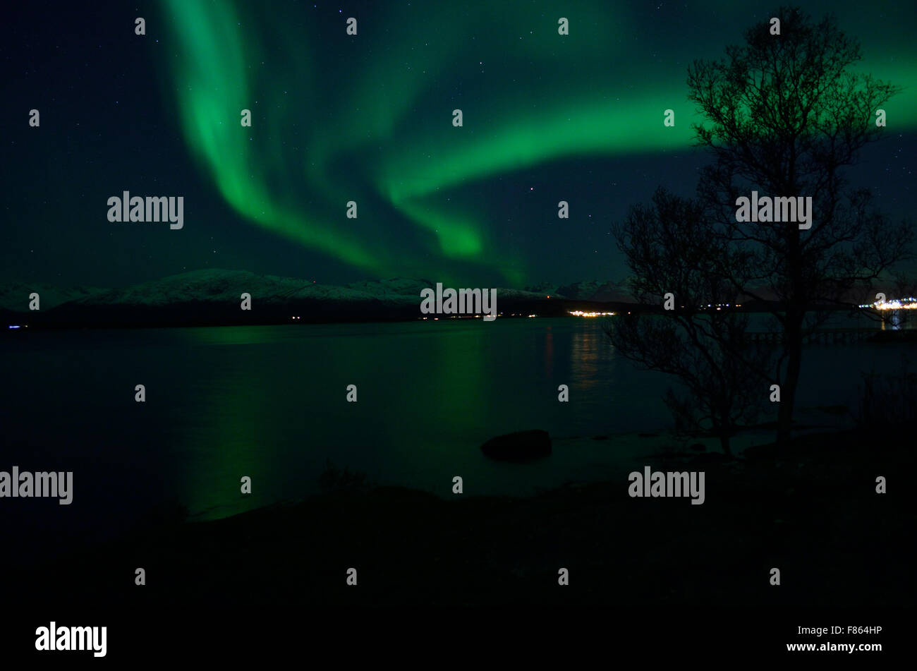 fantastic strong aurora borealis over cold fjord and mountain Stock ...