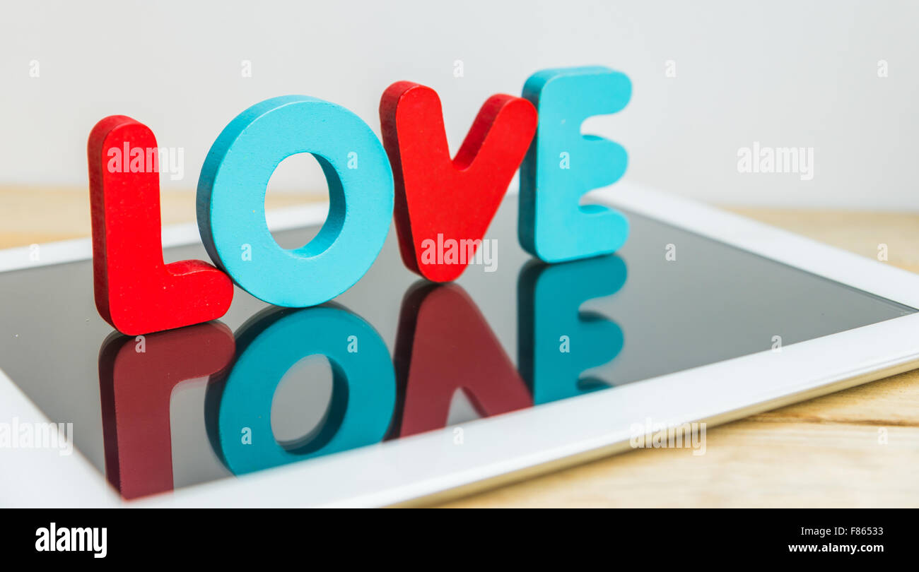 Wooden word LOVE stand on tablet 7 Stock Photo - Alamy