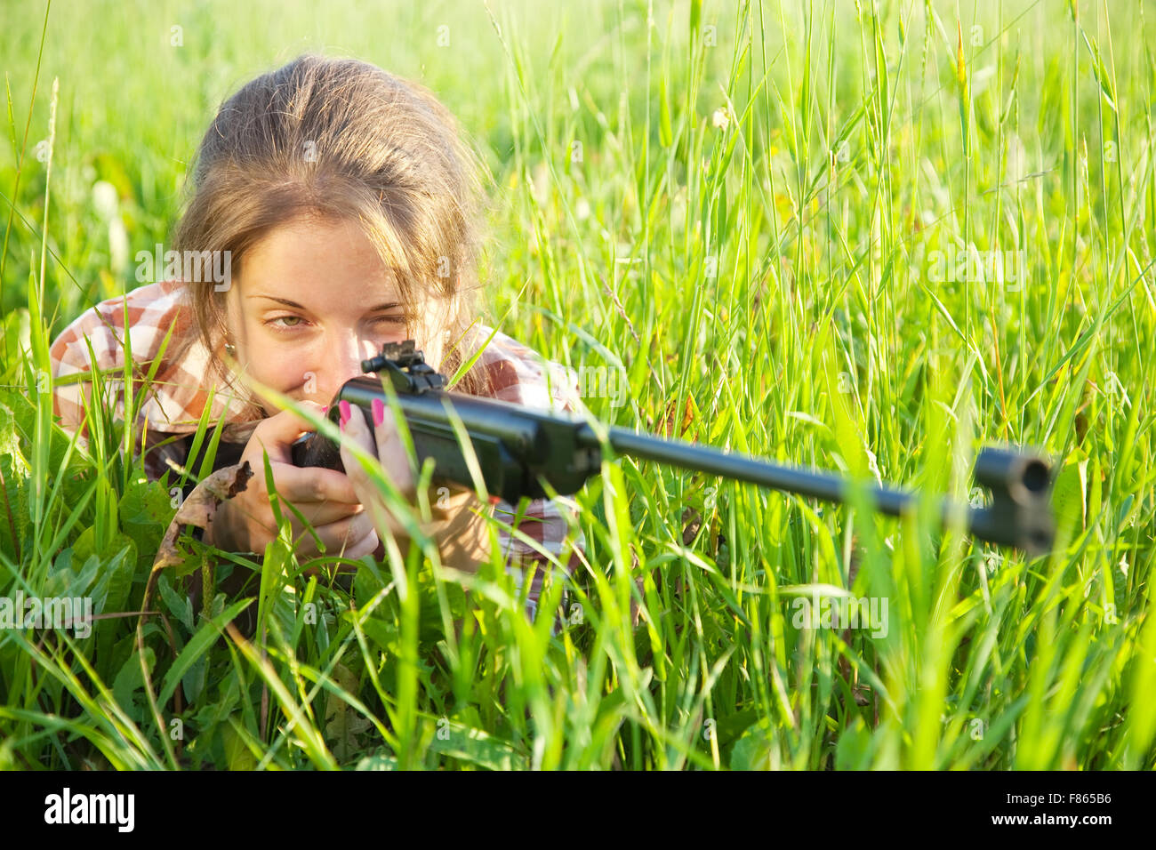 girl aiming a pneumatic air rifle in grass meadow Stock Photo - Alamy