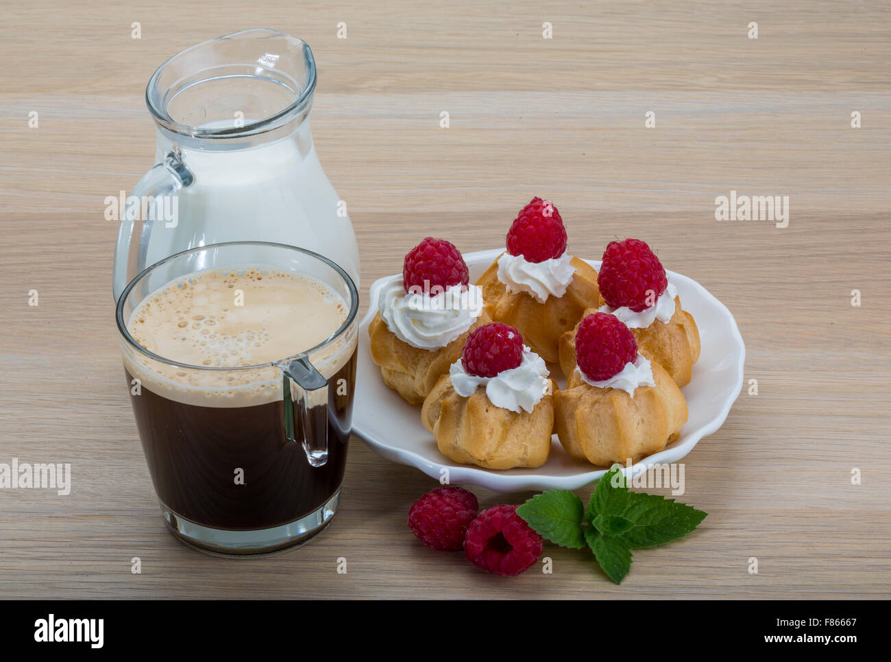 Profiterole with raspberry and cup of coffee Stock Photo - Alamy