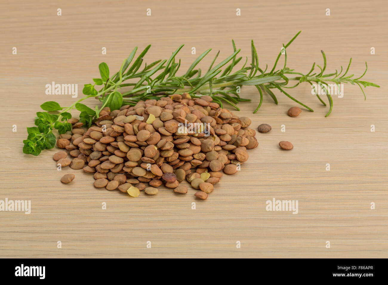 Raw lentils with herbs on the board Stock Photo - Alamy