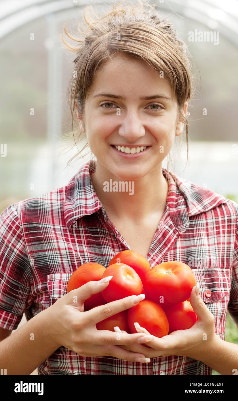 Teenager girl with harvested tomato in greenhouse Stock Photo - Alamy