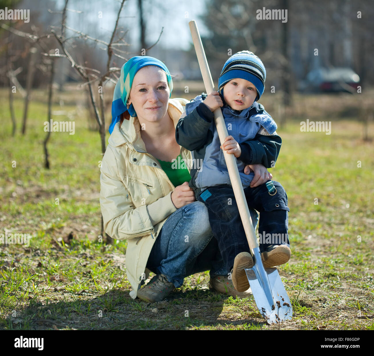 young woman and boy spading with spade in garden Stock Photo - Alamy