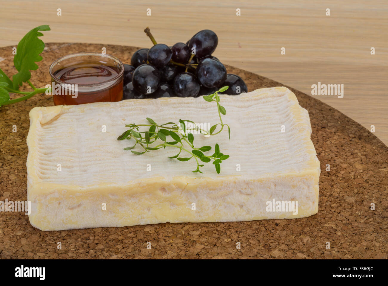 Brie cheese with thyme and grape Stock Photo - Alamy