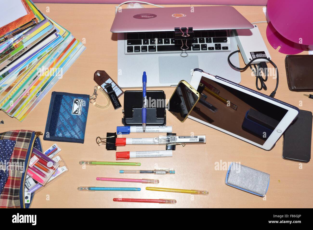 A messy study table of student with electronic devices and study stuffs ...
