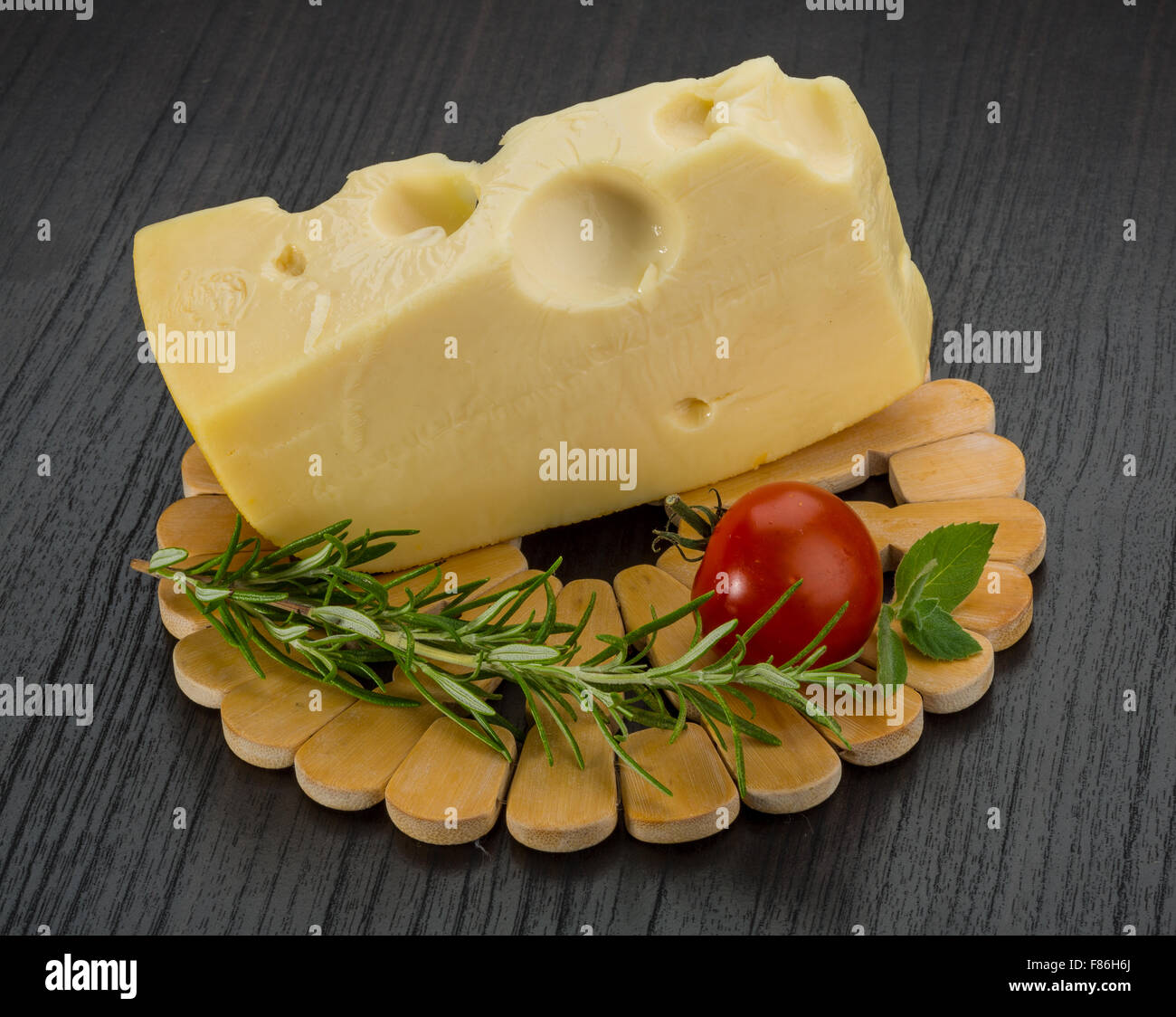 Maasdam cheese on the board with rosemary and mint Stock Photo - Alamy